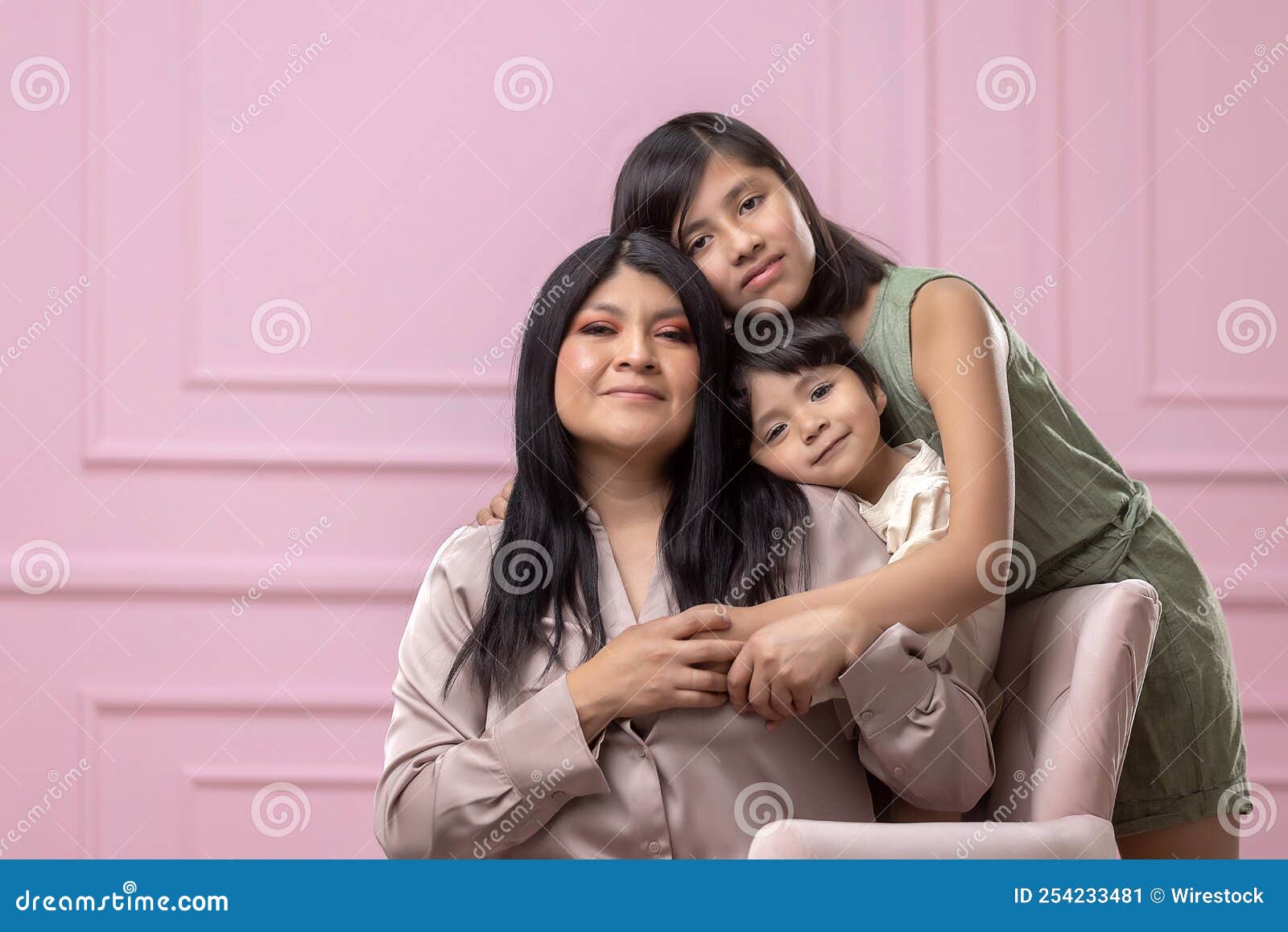 Hispanic Mother with Her Two Children Hugging on a Pink Background ...