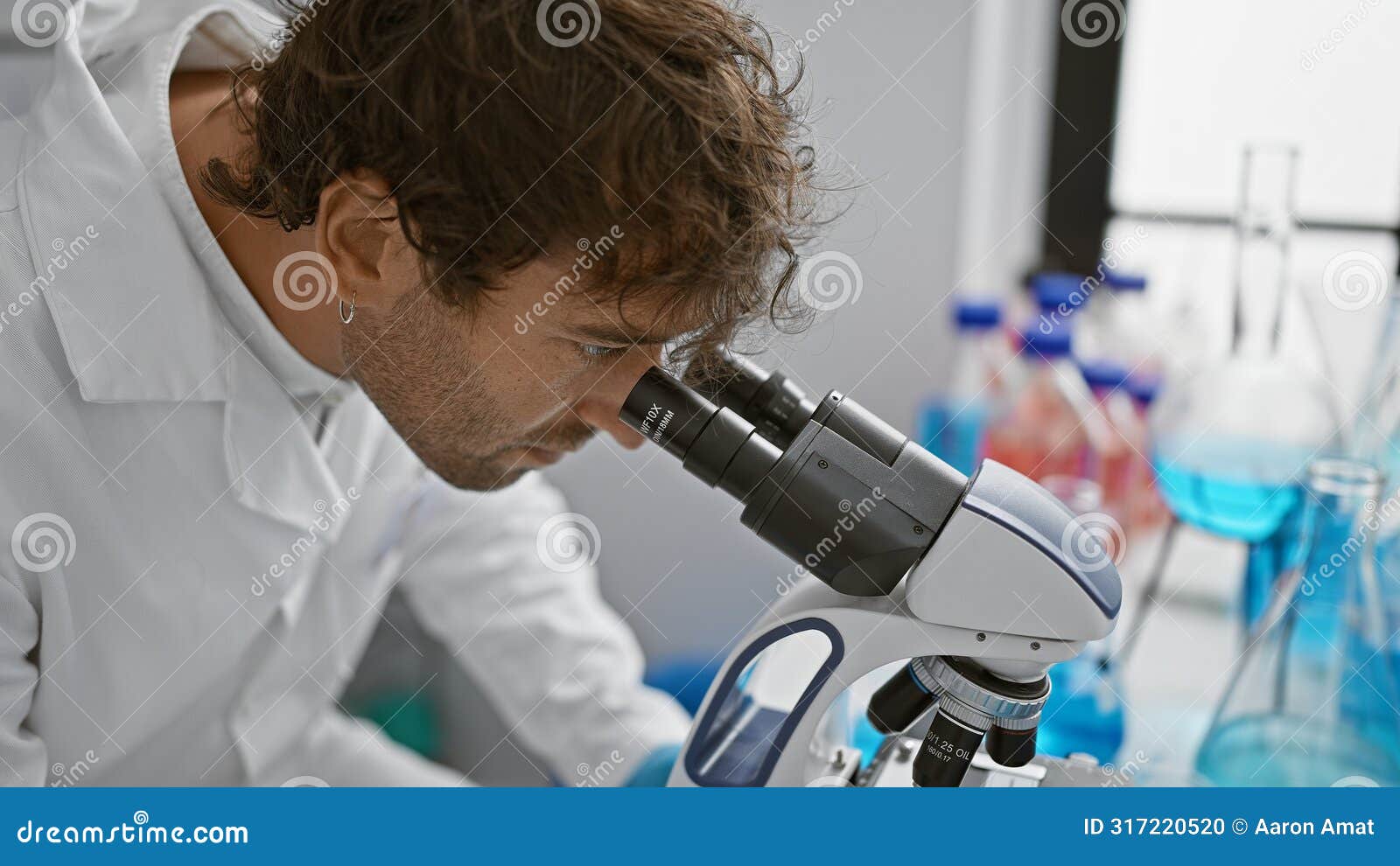Hispanic Researcher Man Examines Samples Using a Microscope in a Modern ...
