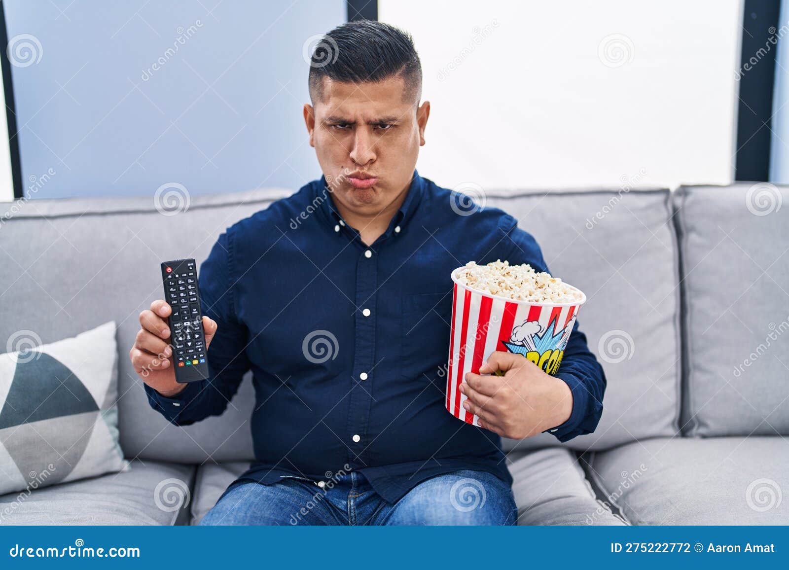 Hispanic Young Man Eating Popcorn Using Tv Control Depressed and Worry ...