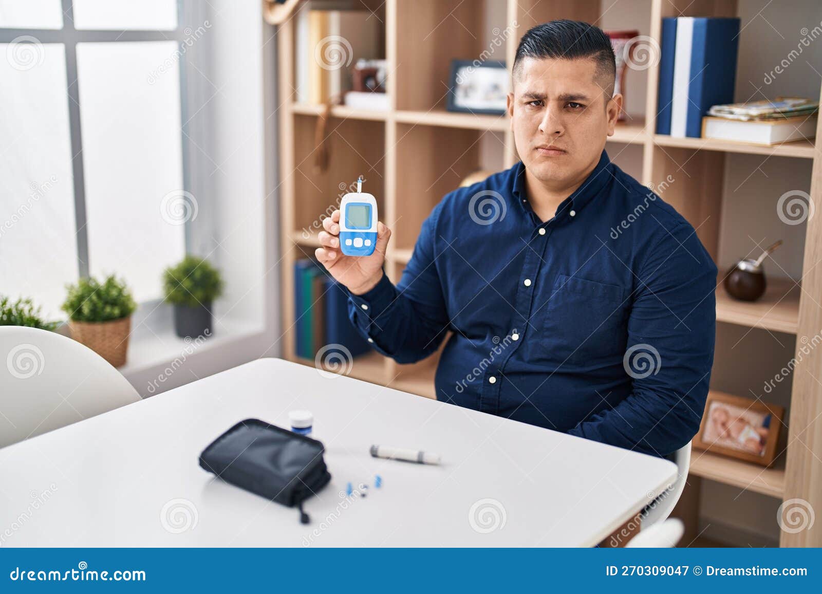 Hispanic Young Man Holding Glucometer Device Thinking Attitude and ...