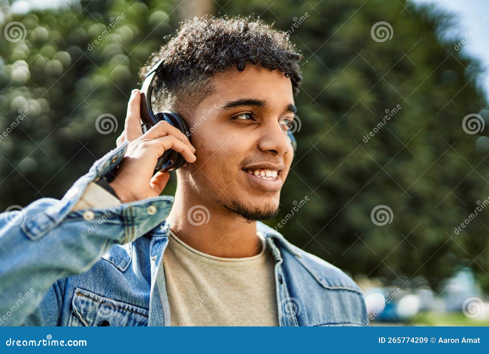 Hispanic Young Man Listening To Music Wearing Headphones At The