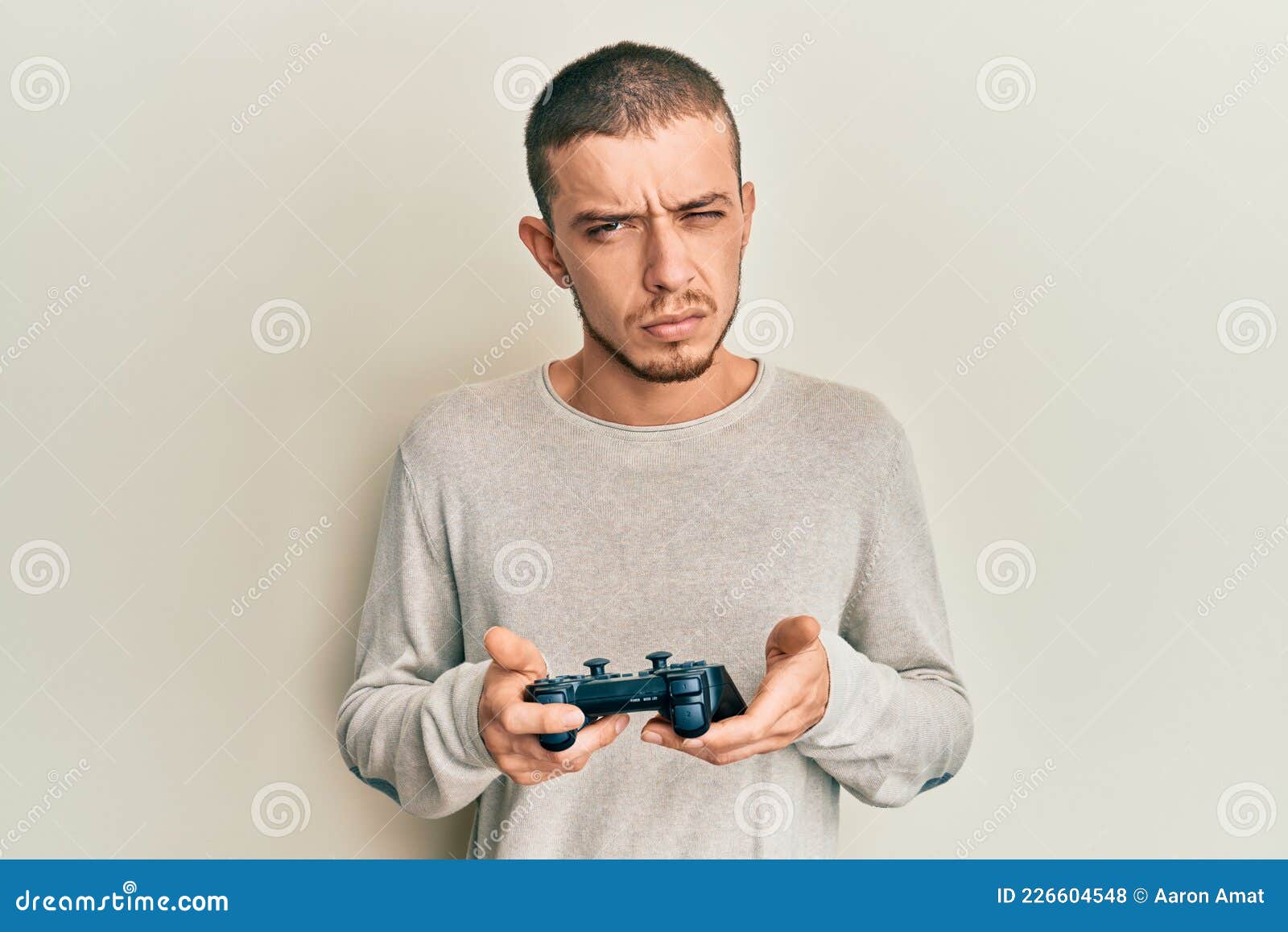 Hispanic Young Man Playing Video Game Holding Controller Clueless and ...