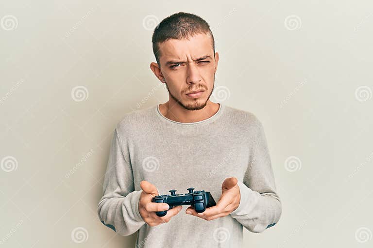 Hispanic Young Man Playing Video Game Holding Controller Clueless and ...