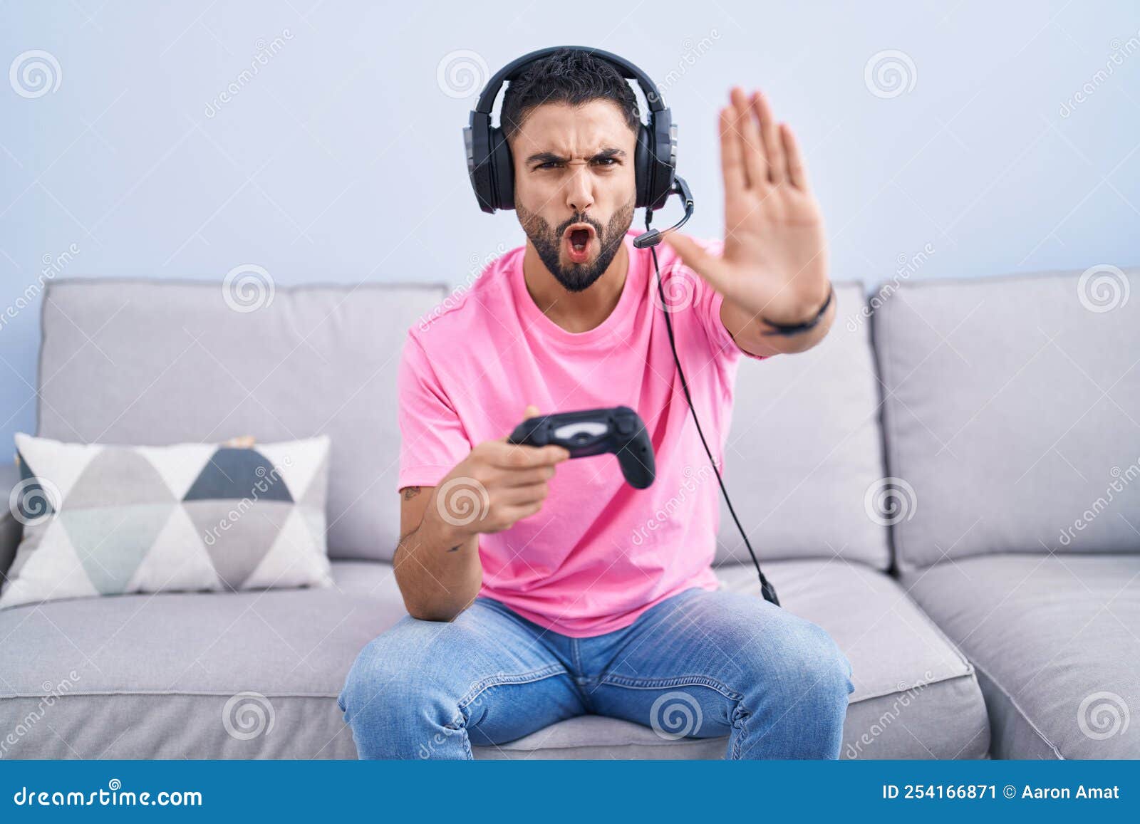 Hispanic Young Man Playing Video Game Holding Controller Sitting on the ...