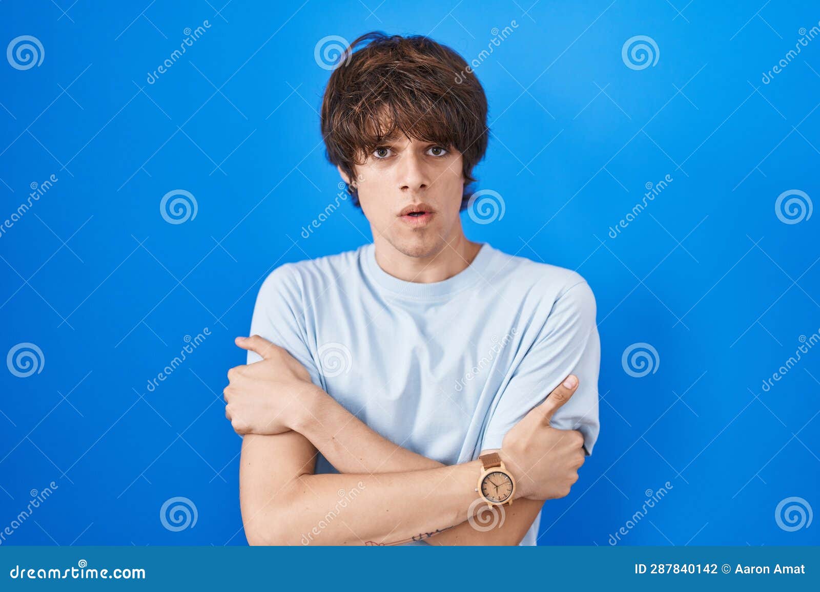 Hispanic Young Man Standing Over Blue Background Shaking and Freezing ...
