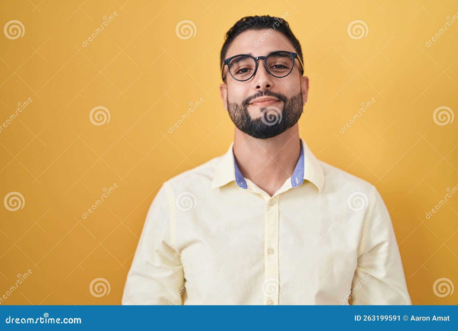 Hispanic Young Man Wearing Business Clothes And Glasses With Hands Together And Crossed Fingers