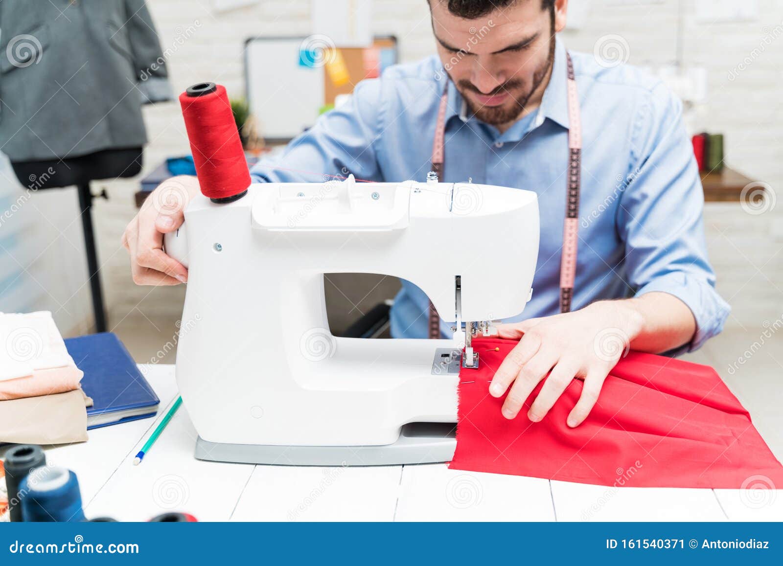 Male Dressmaker Using Machine at Workbench in Studio Stock Image ...
