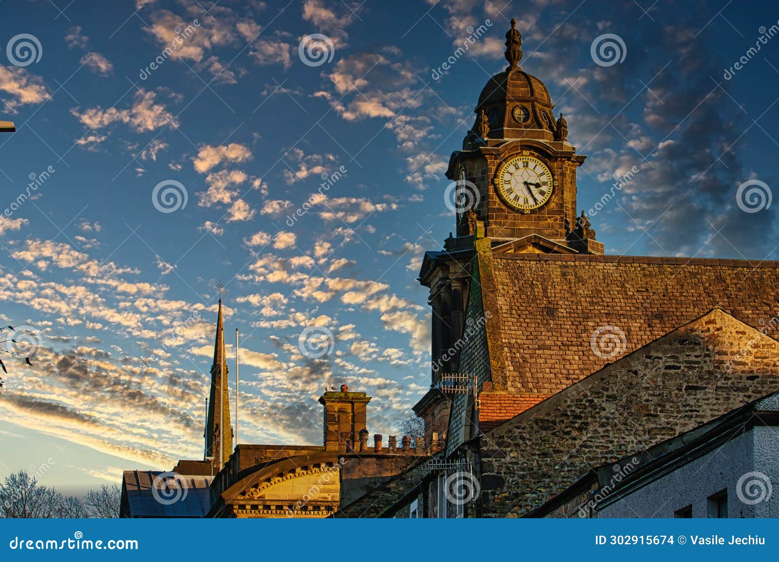 Historic Clock Tower Against a Vibrant Sunset Sky with Scattered Clouds ...