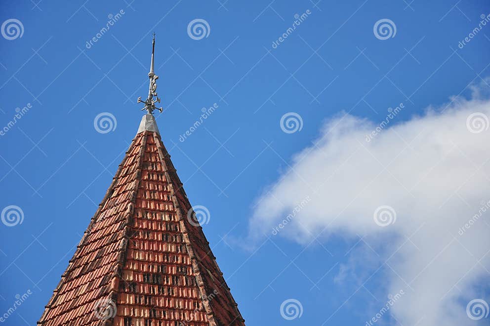 Historic Tower with Triangular Roof Against Blue Sky and Single White ...