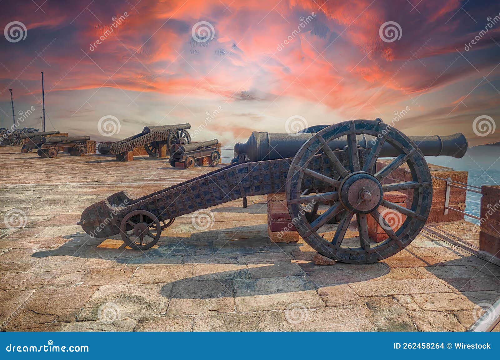 Cannons of Artillery Standing on a Stone Platform by the Sea at Sunset ...