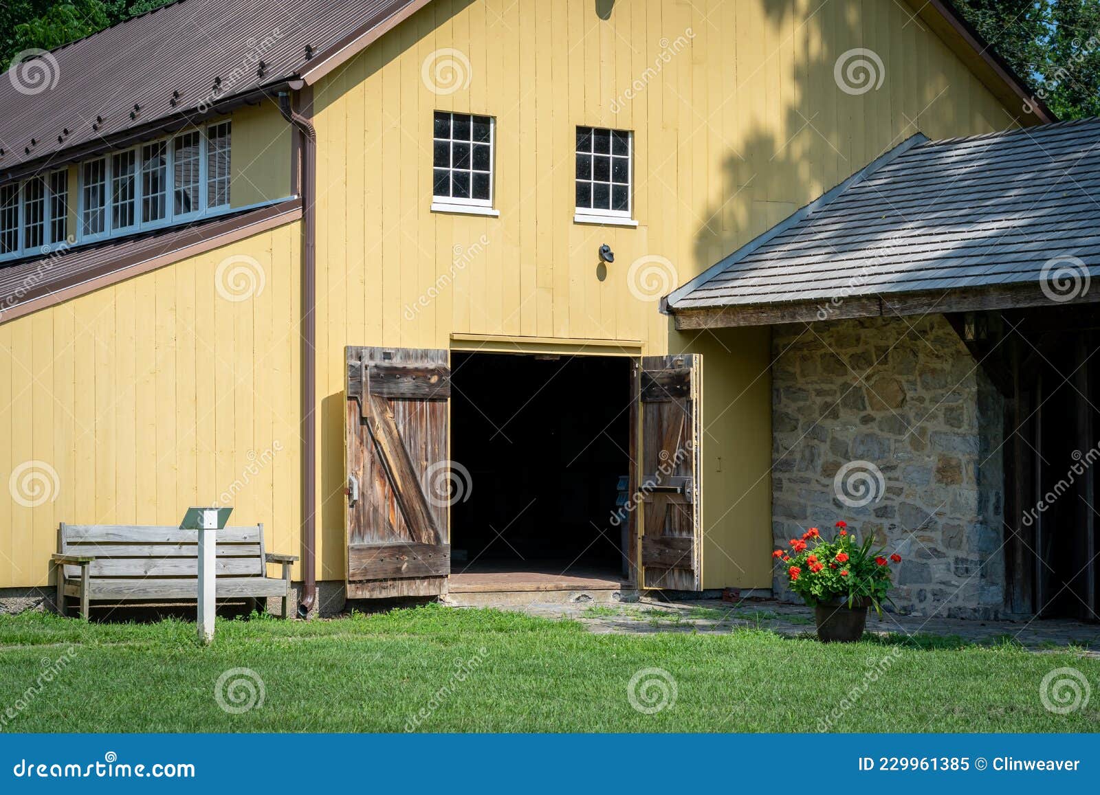 Historical Yellow Barn stock image. Image of bench, grass - 229961385