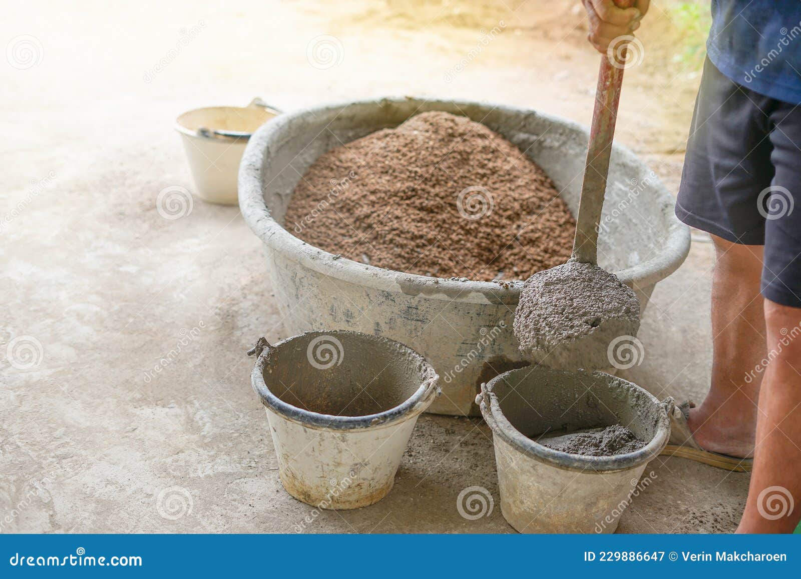 A Hoe Scoops Mixed Cement from Basin into Bucket for Construction Work ...