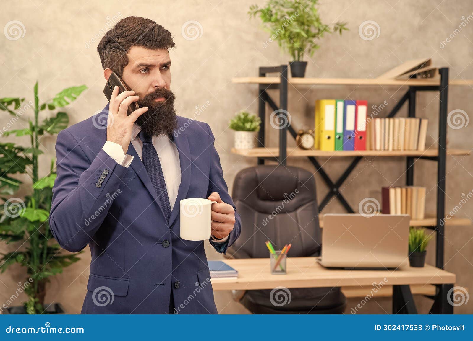Hold on. Serious Man Being on Phone Drinking Coffee. Phone Call at Work ...