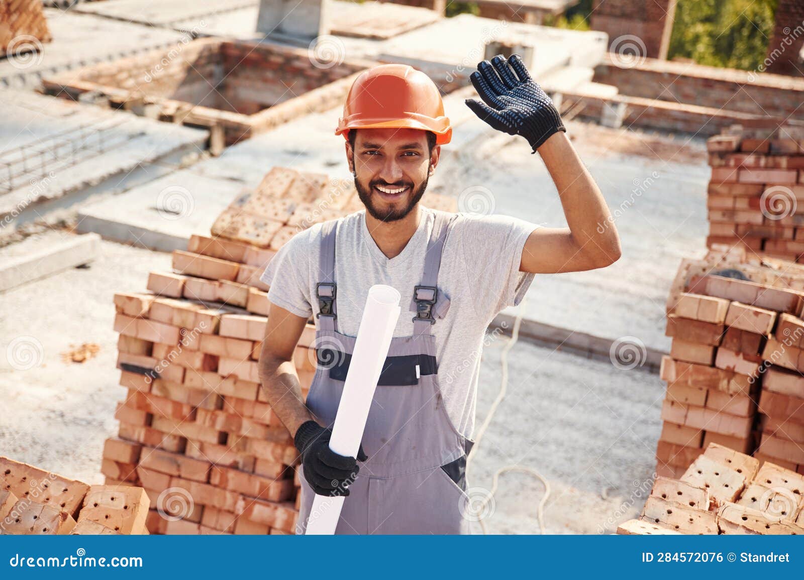 Showing and Holding Little Shovel and Brick. Handsome Indian Man is on ...
