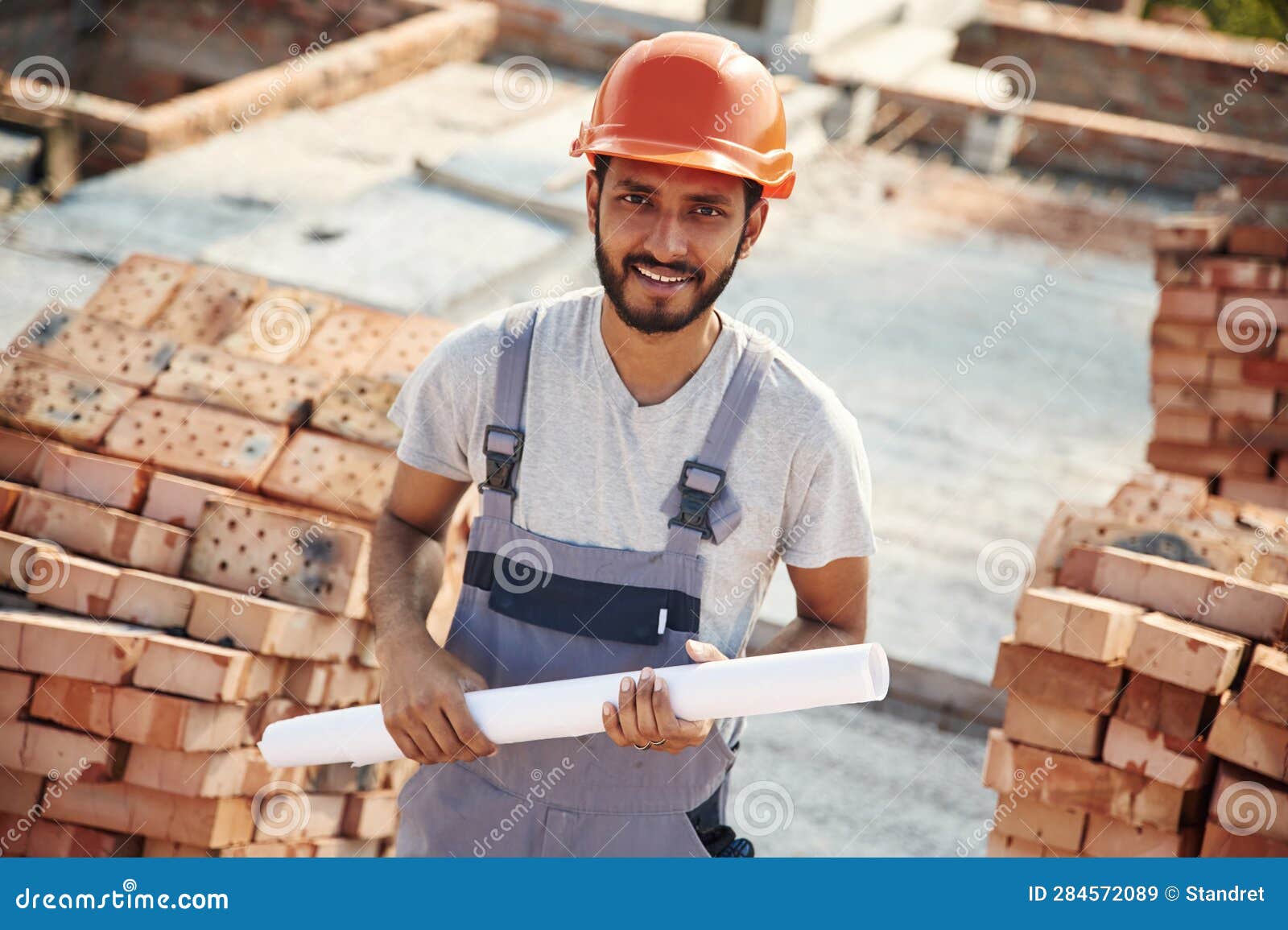 Showing and Holding Little Shovel and Brick. Handsome Indian Man is on ...