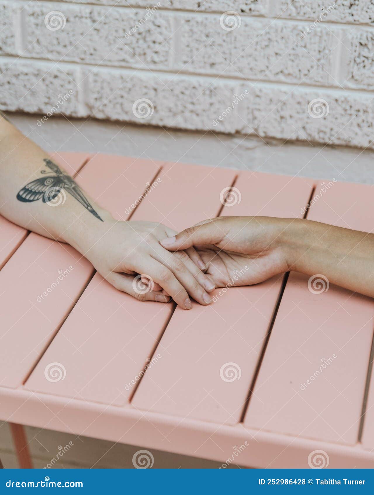 Holding hands on a table stock photo. Image of hand - 252986428