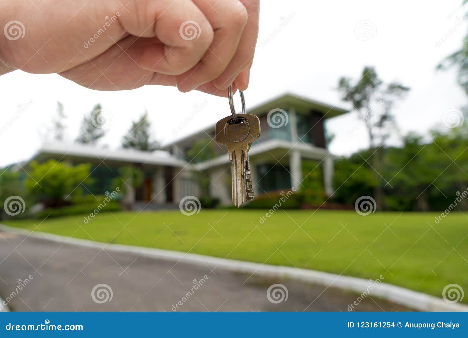 Holding House Keys on House Shaped in Front of a New Home Stock Photo ...
