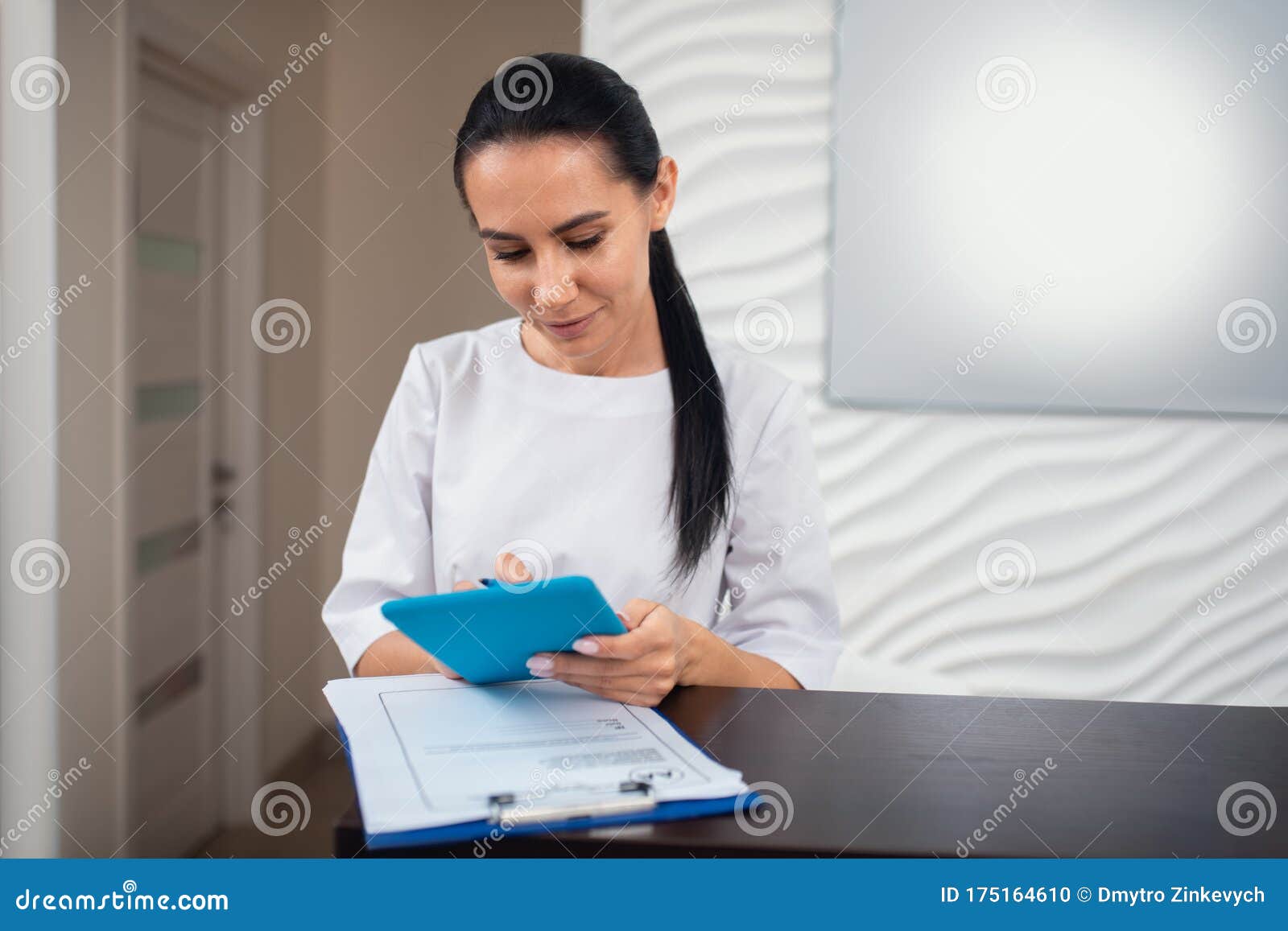 Receptionist Holding Little Tablet while Making Appointment Stock Photo ...