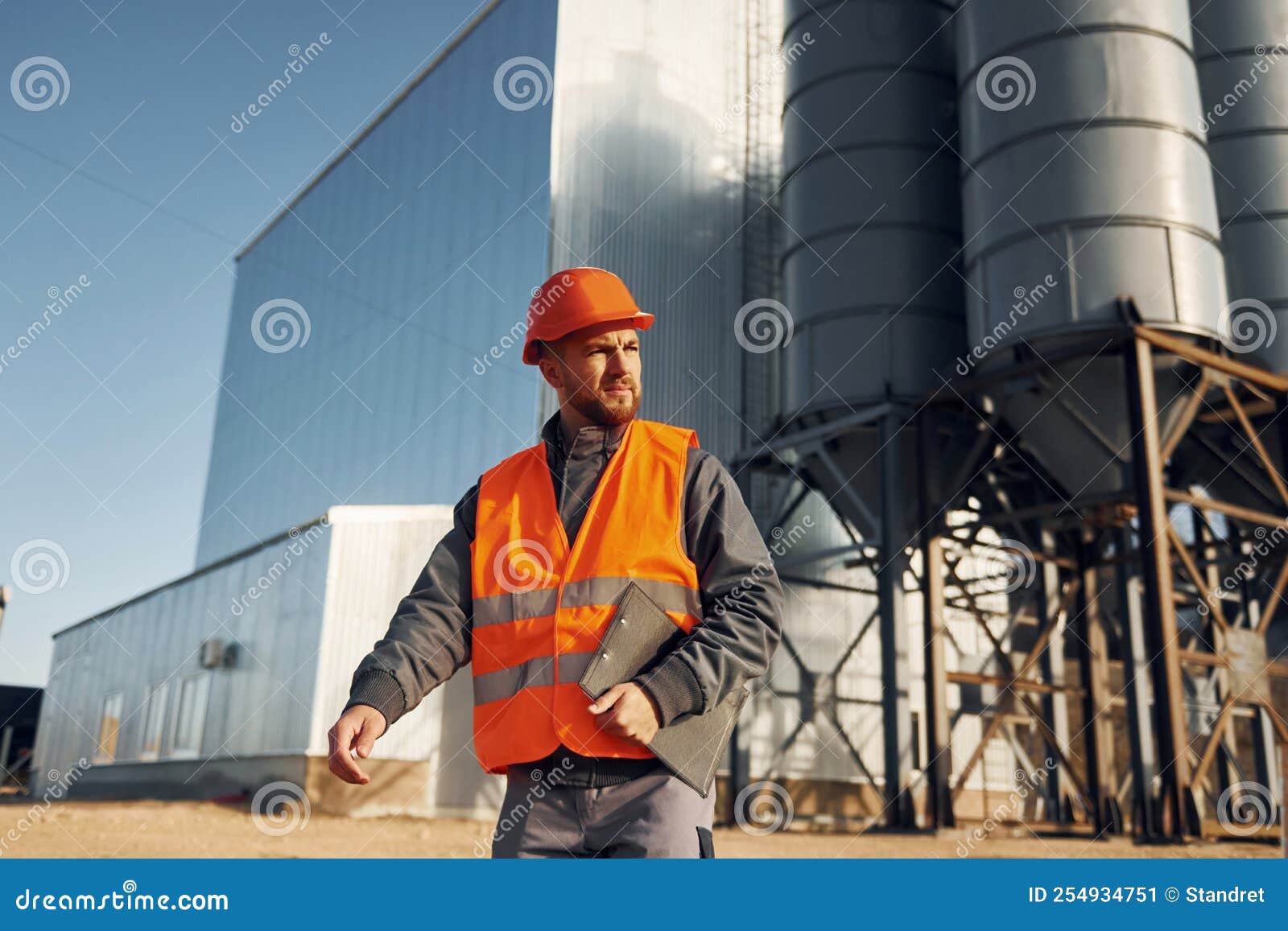Holding Notepad in Hands. Construction Worker in Uniform is Outdoors ...