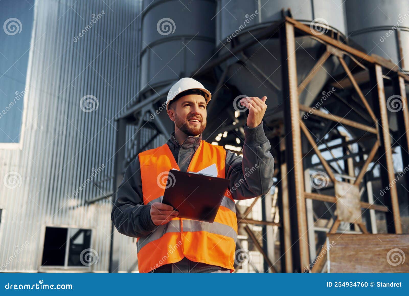 Holding Notepad in Hands. Construction Worker in Uniform is Outdoors ...