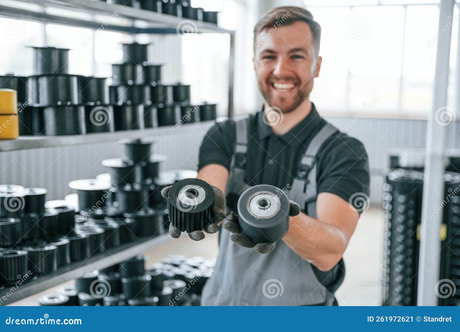 Holding Objects and Smiling. Man in Uniform is in Workstation ...