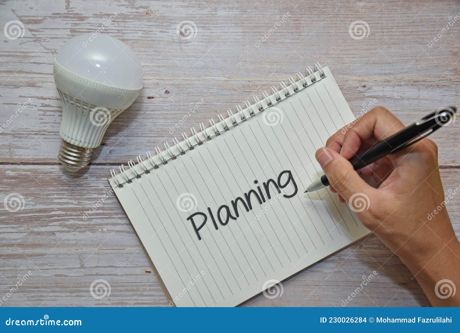 Holding a Pen with PLANNING Text on Notebook and Bulb. Business Concept ...
