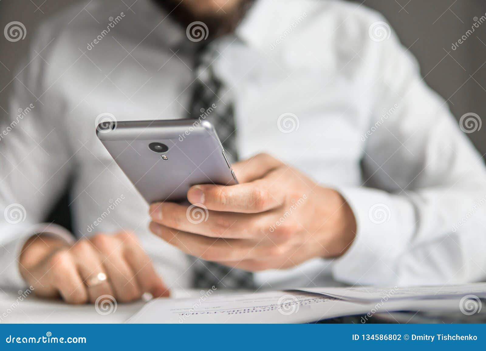Holding Smartphone in Hand. Businessman Work with Computer on Table in ...