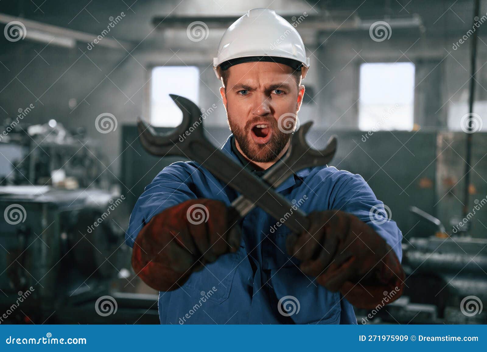 Holding Two Wrenches. Factory Worker in Blue Uniform is Indoors Stock ...
