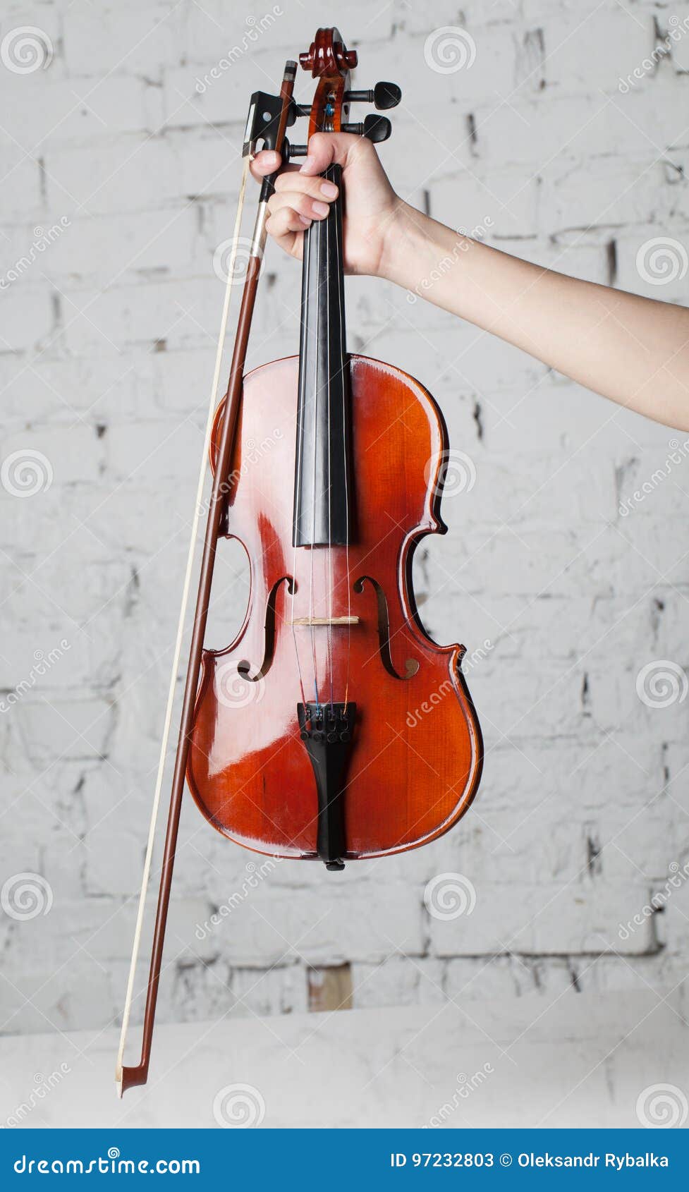 Holding Violin With Bow Under White Grand Piano With Brick Wall ...