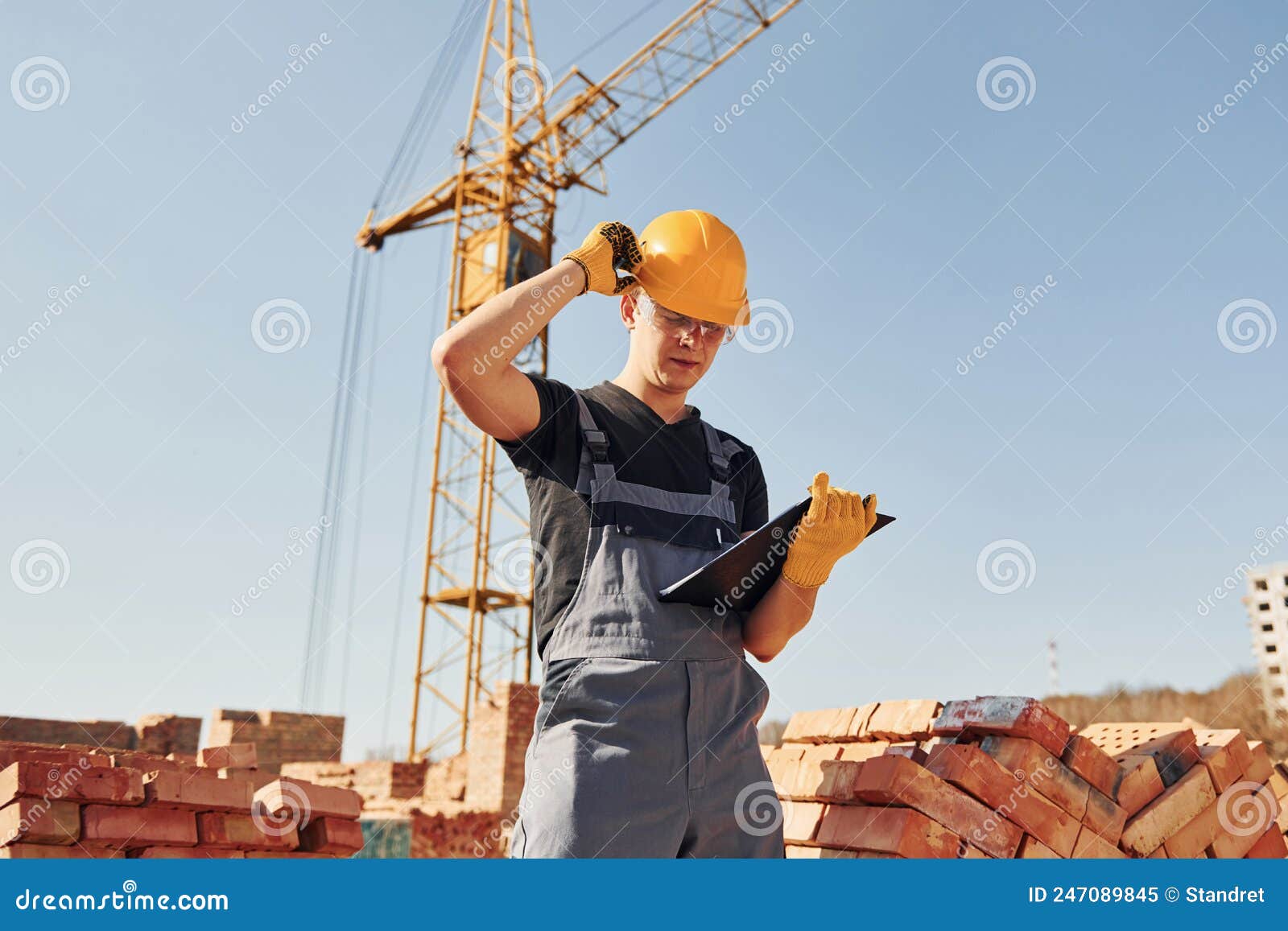 Holds Notepad with Documents. Construction Worker in Uniform and Safety ...