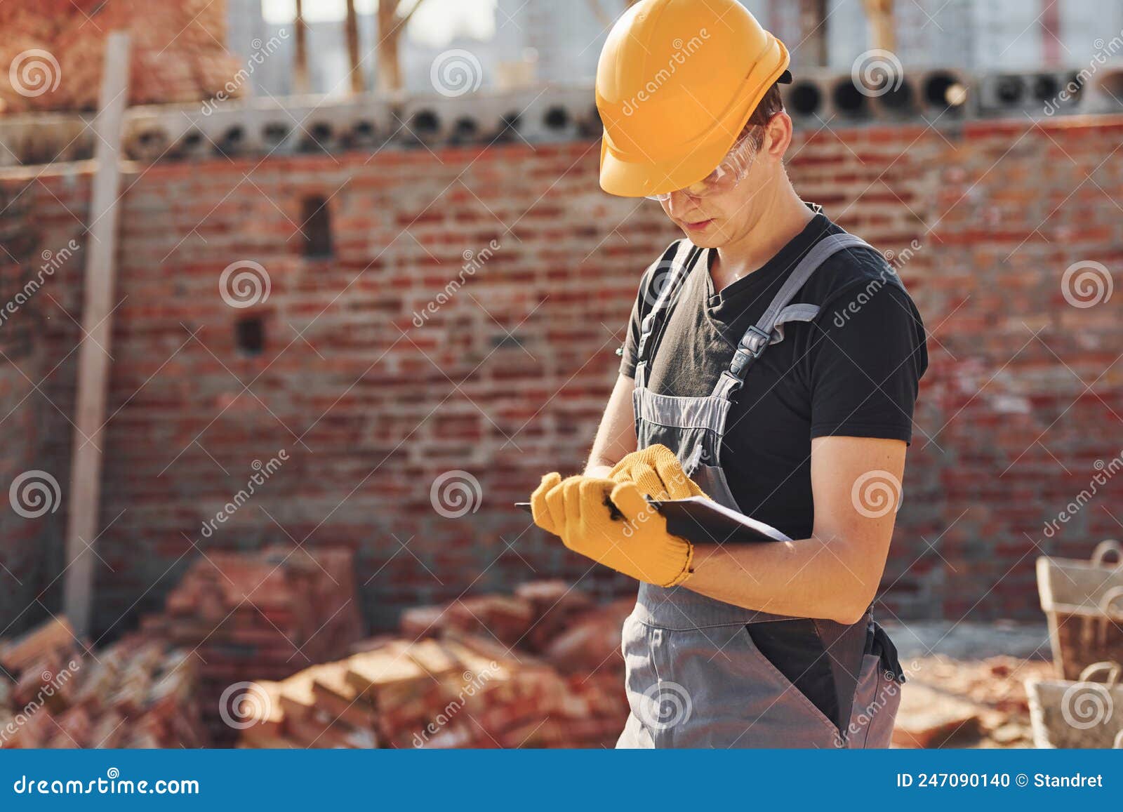 Holds Notepad with Documents. Construction Worker in Uniform and Safety ...