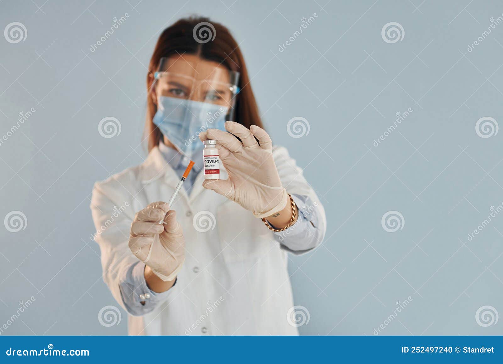Holds Syringe Young Female Doctor In White Coat Is Standing Indoors