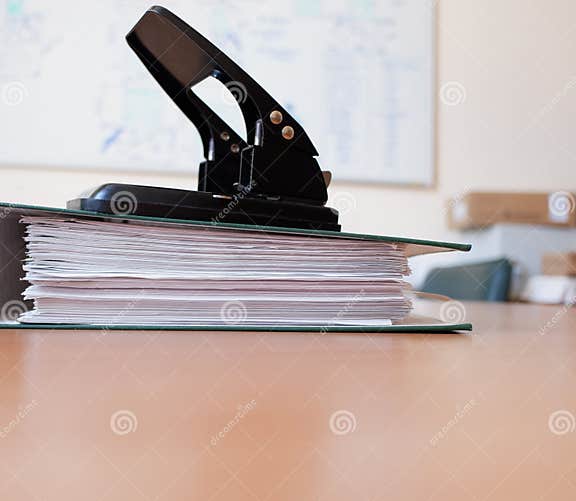 Hole Punch on a Green Folder with Documents Lie on the Office Table ...