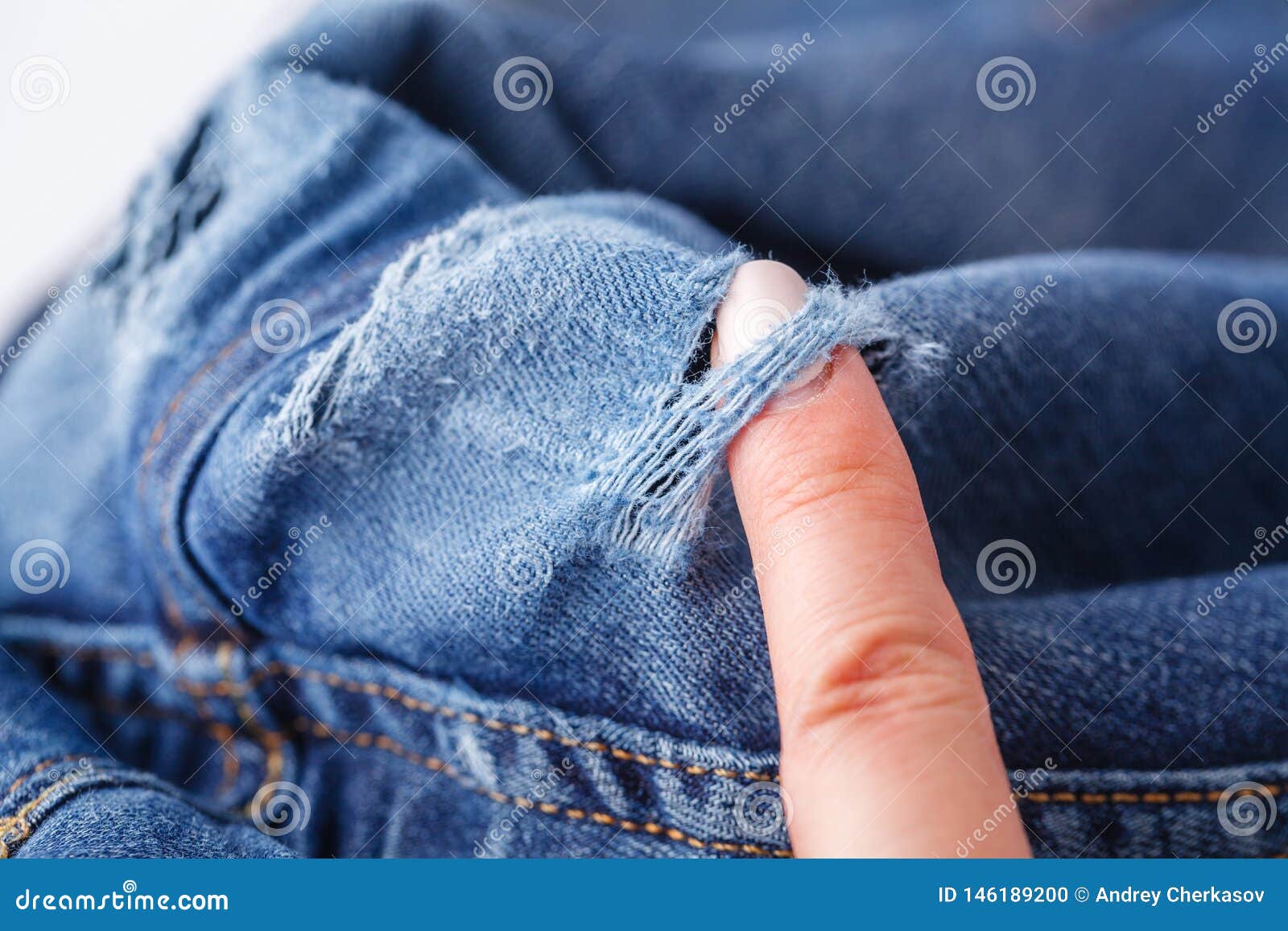 Hole and Threads on Denim Jeans. Ripped Destroyed Torn Blue Jeans ...