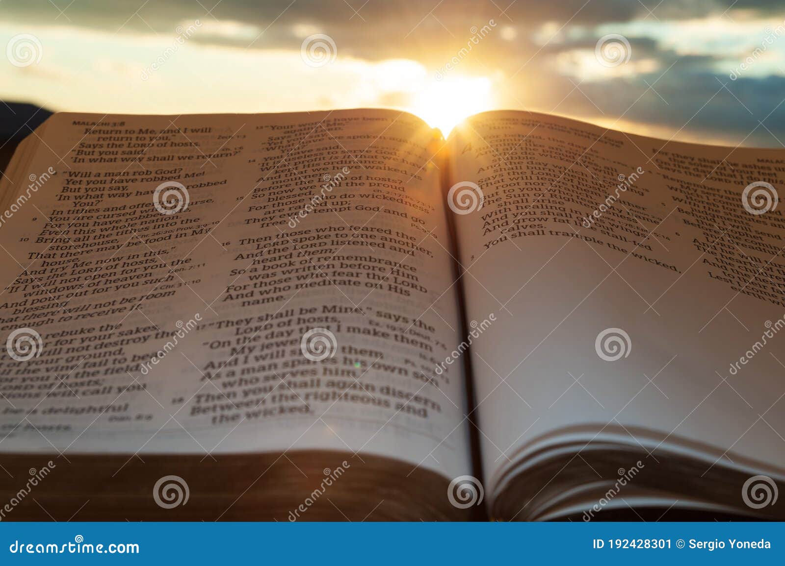 Holy Bible Open at Sunset with Highlight on Malachi 4:2. Background ...