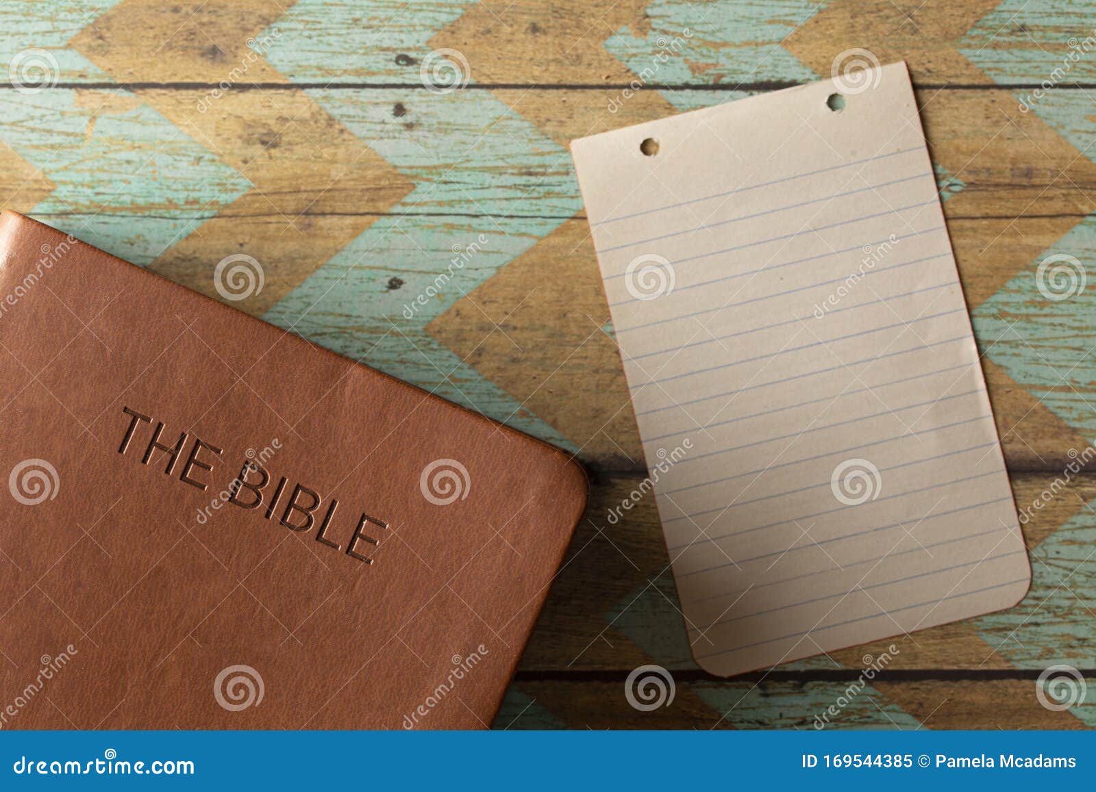 Holy Bible on a Rustic Wooden Table with a Blank Piece of Antique Paper ...
