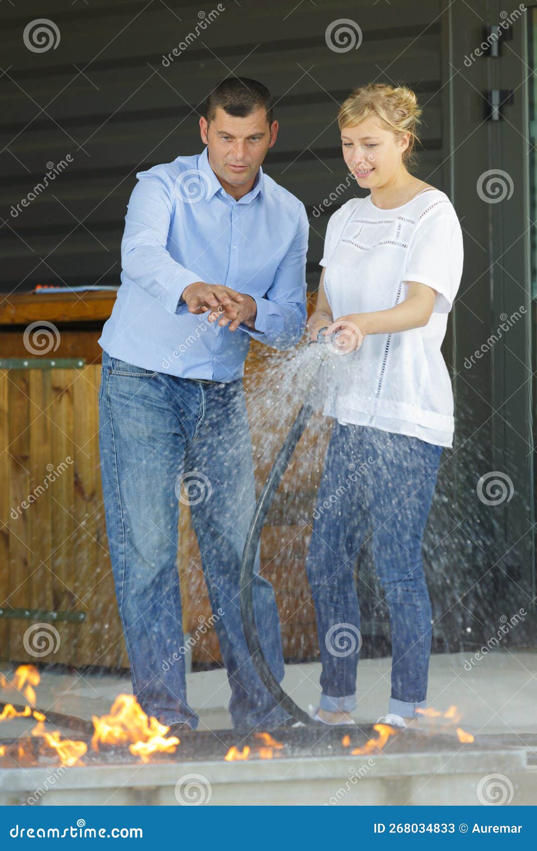 Hombre Y Mujer En Simulacro De Incendio Extinguiendo Llamas Con Agua ... Hombre Y Mujer En Simulacro De Incendio Extinguiendo Llamas Con Agua ...
