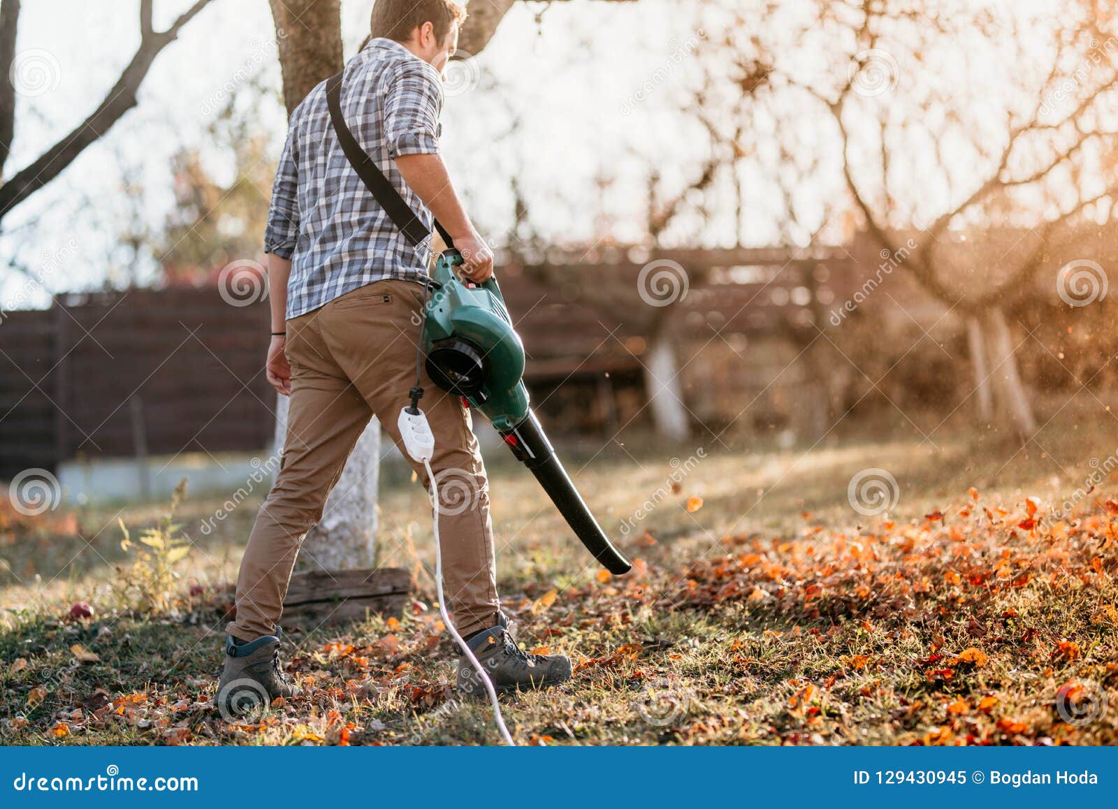 Home Gardening Industry - Male Using Leaf Blower during Sunset Stock ...