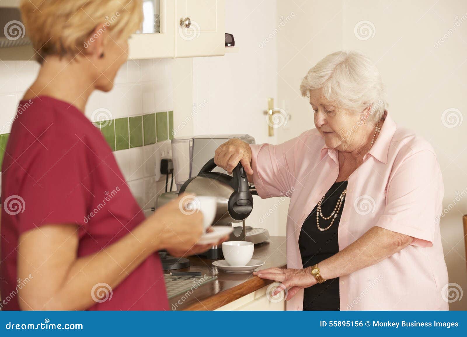 Home Help Sharing Cup of Tea with Senior Woman in Kitchen Stock Photo ...