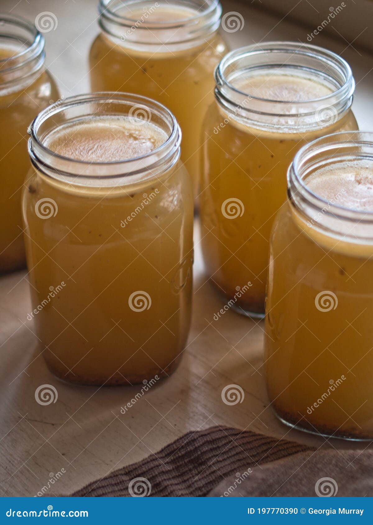 Home Made Bone Broth in Glass Jars on Kitchen Table. Natural Light ...