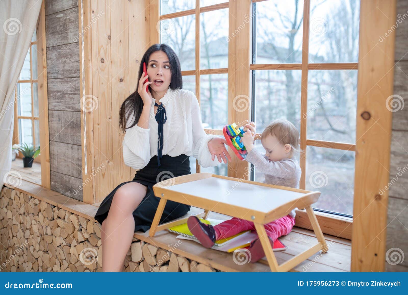 Mom Playing Learning Game with Daughter on Windowsill, Talking on Phone ...