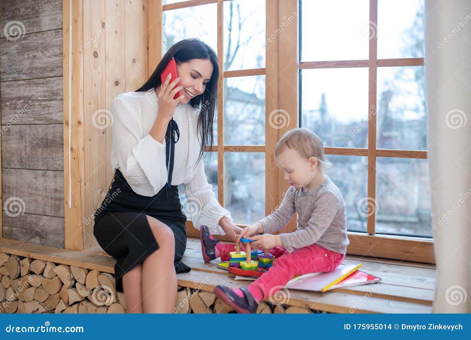 Young Mom Sitting on Windowsill, Talking on Phone, Playing Learning ...