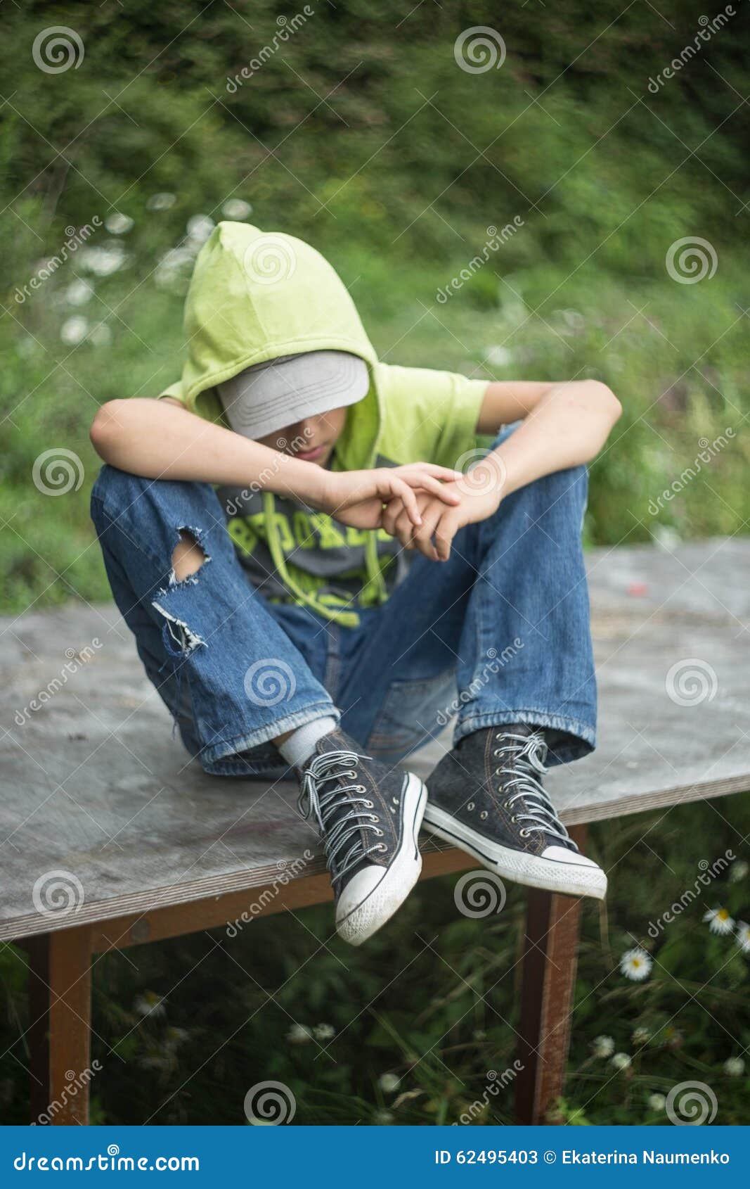 A Homeless Boy Sits on a Bench with Her Head Bowed Down Stock Image ...