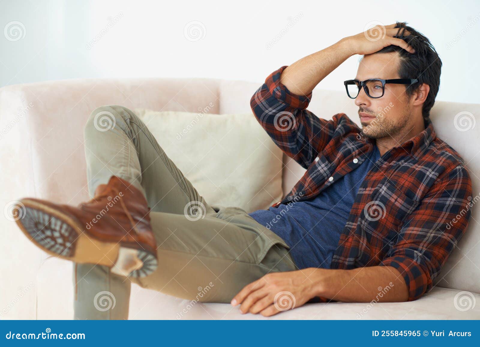 Homely Handsomeness. a Handsome Young Man Sitting on the Sofa at Home ... Homely Handsomeness. a Handsome Young Man Sitting on the Sofa at Home ...