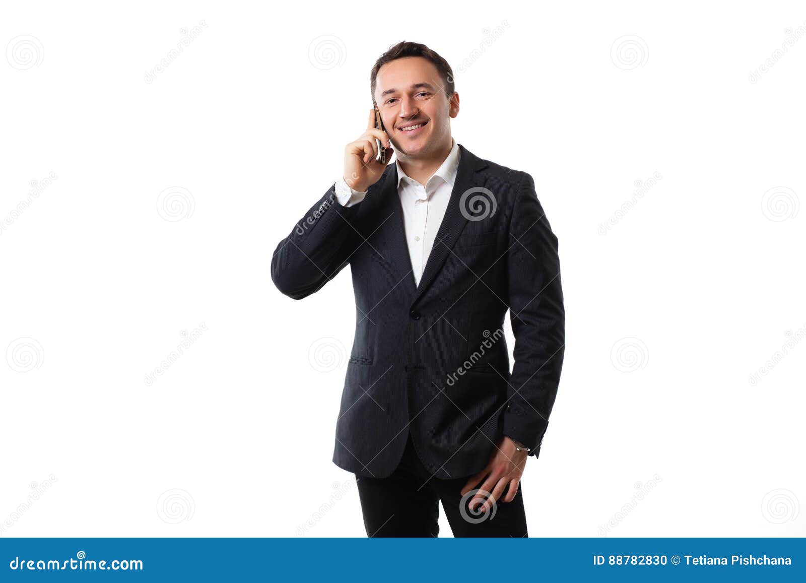 Homem Novo Em Um Terno Em Um Fundo Branco Que Fala No Telefone Foto de ... Homem Novo Em Um Terno Em Um Fundo Branco Que Fala No Telefone Foto de ...