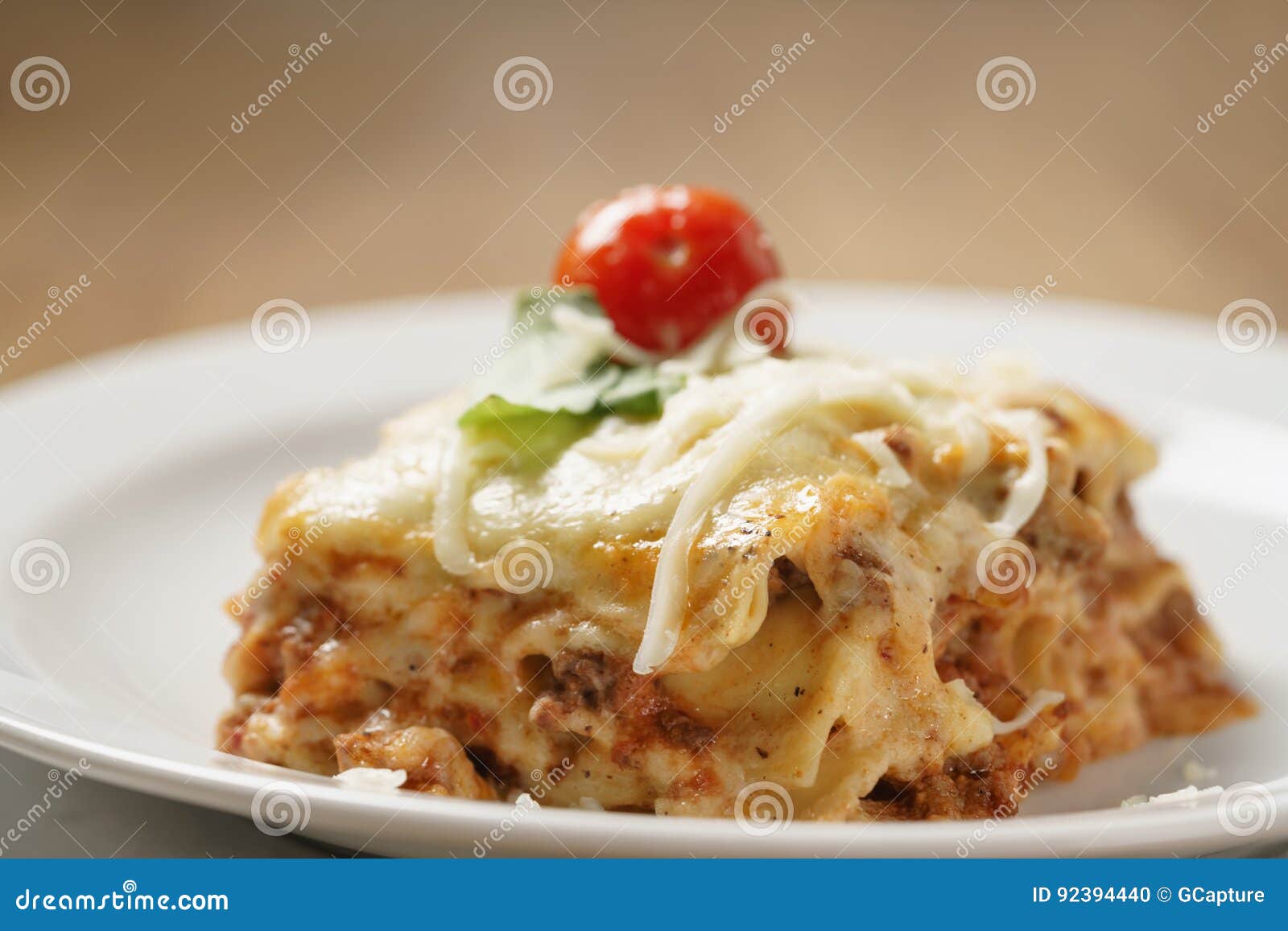 Homemade Lasagna Portion on White Plate on Wood Table Stock Photo ...