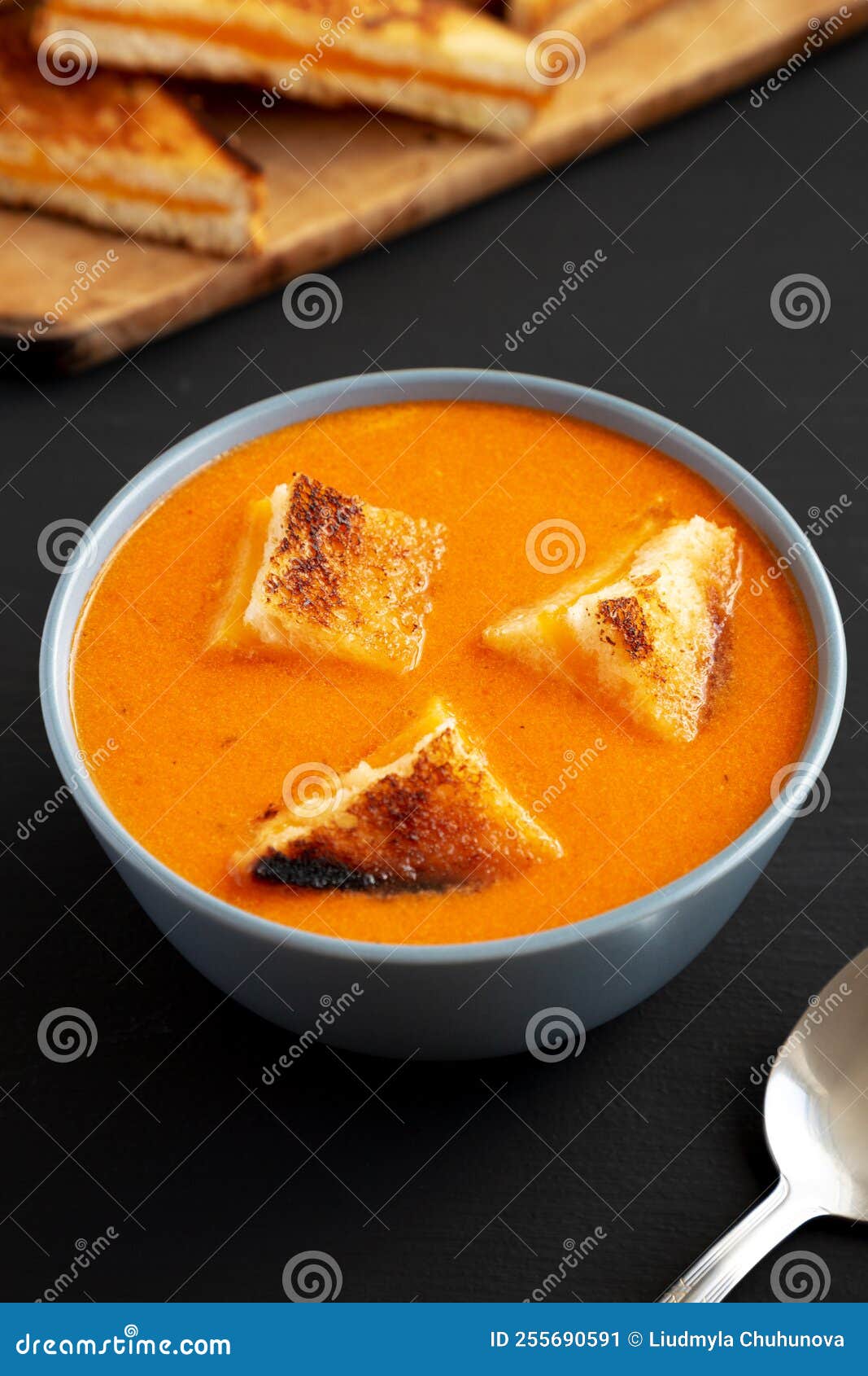Homemade Tomato Soup With Grilled Cheese Croutons On A Black Background