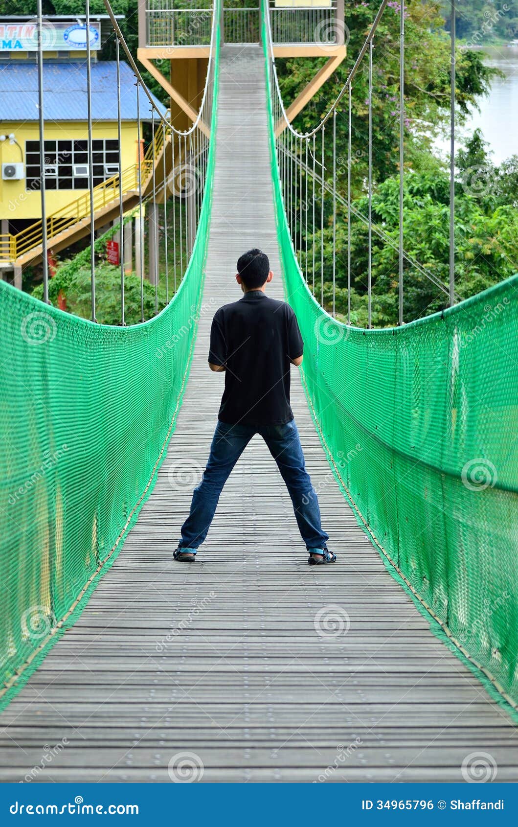 Homme sur le pont suspendu photo stock. Image du over - 34965796