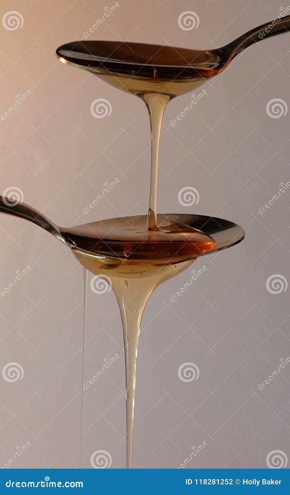 Honey drizzling off spoons stock photo. Image of honey - 118281252