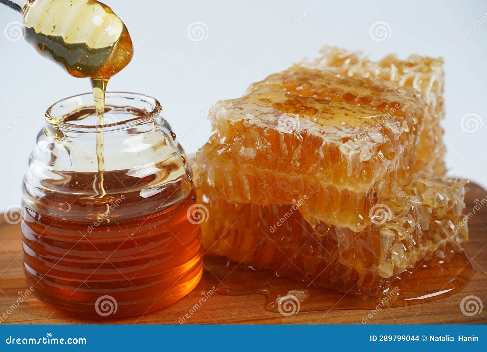 Honey Jar and Stick with Liquid Honey Flowing on Honeycomb Pieces in a ...